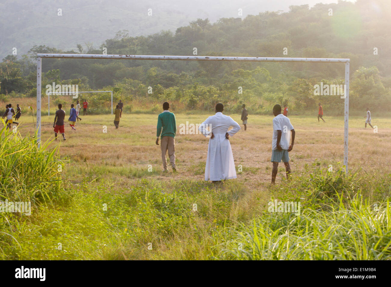 Catholic priest watching a soccer game Stock Photo - Alamy