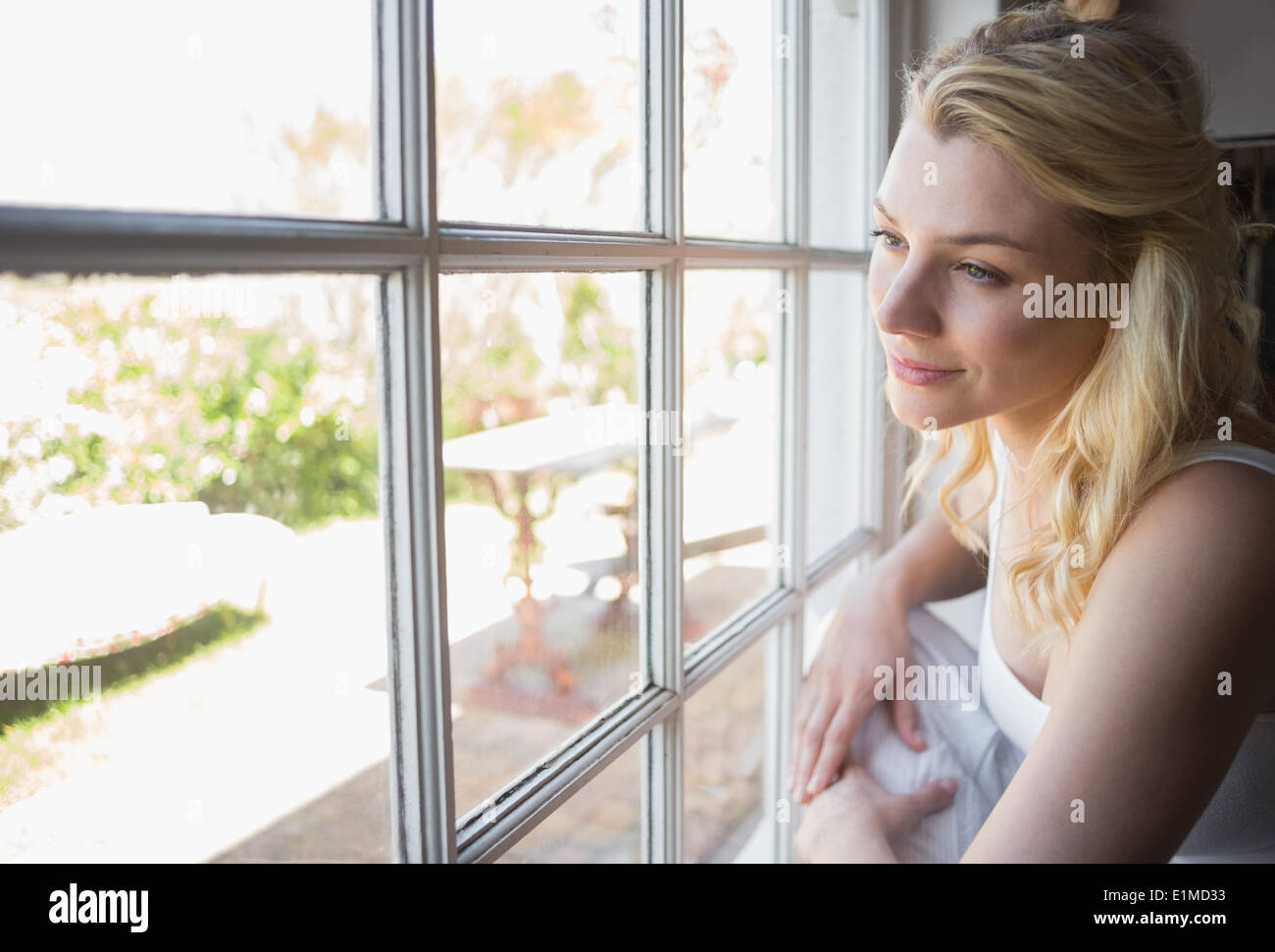 Pretty blonde looking out the window Stock Photo - Alamy