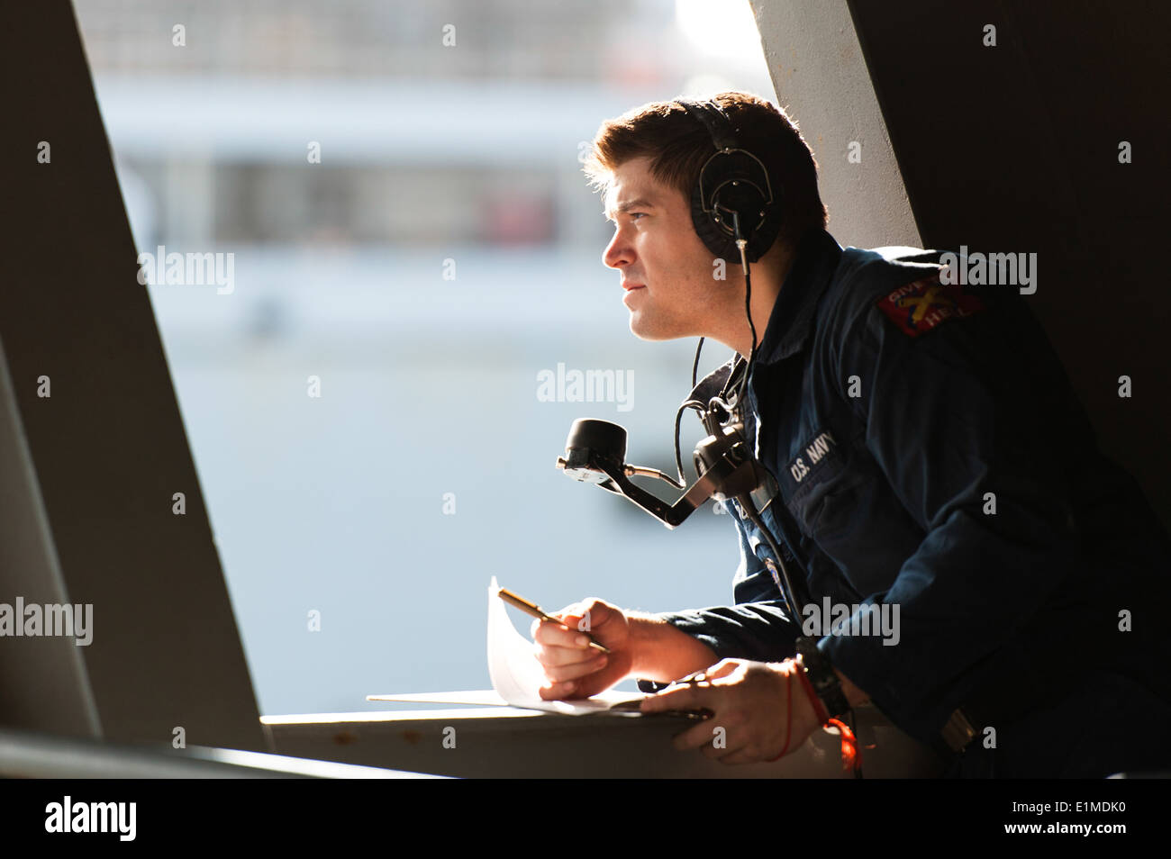 U.S. Navy Seaman Anthony Rouillard fills out the deck control log ...