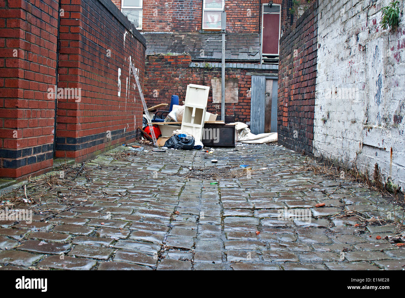 Household rubbish left lying about in a dirty back street cobble stoned ...