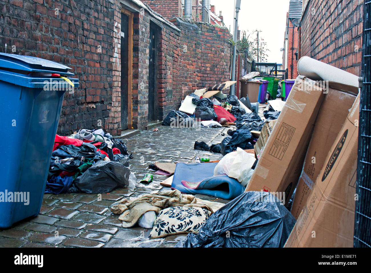 Household rubbish left lying about in a dirty back street cobble stoned ...