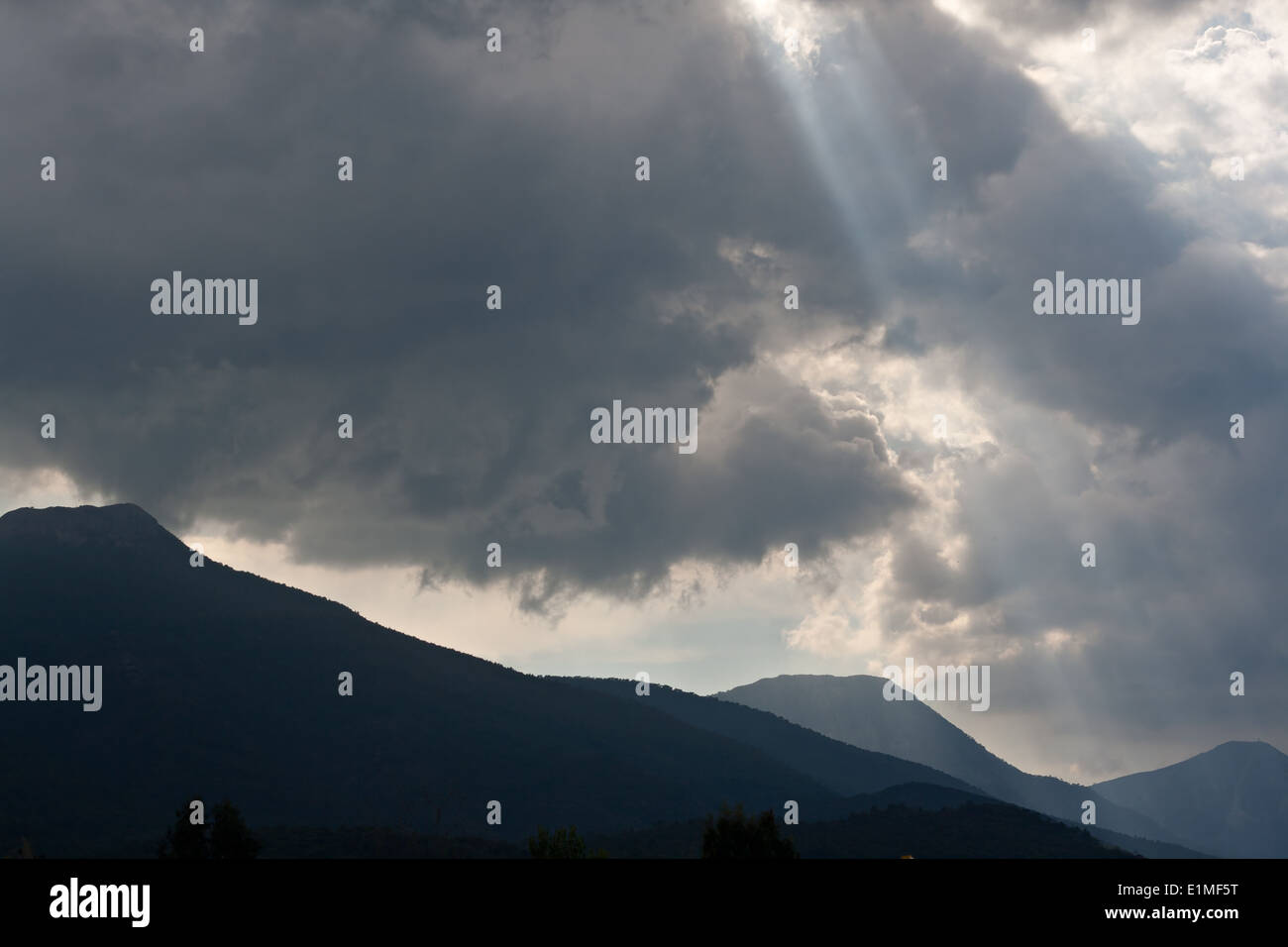 Sun rays shining through dramatic storm clouds Stock Photo - Alamy