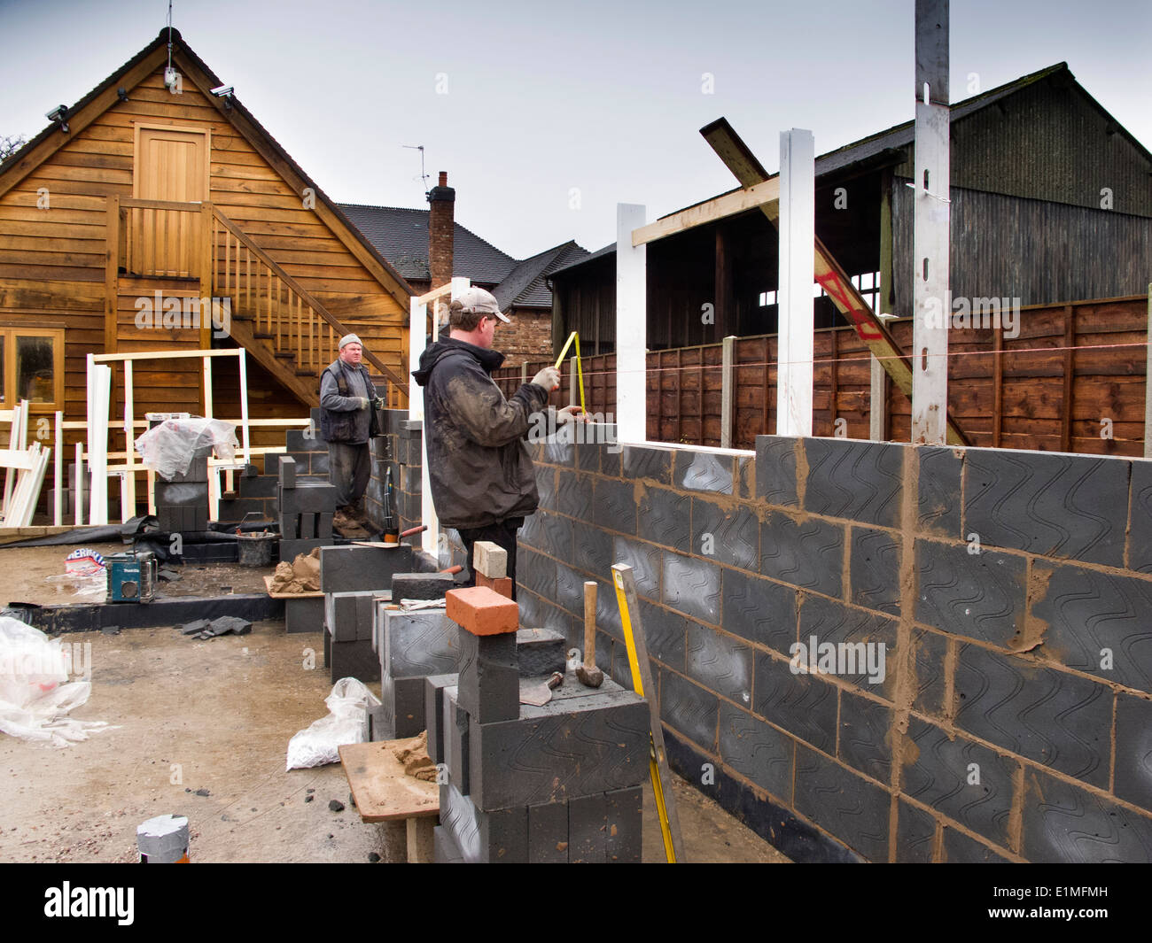 self building house, bricklayers laying thermalite blocks to form ...