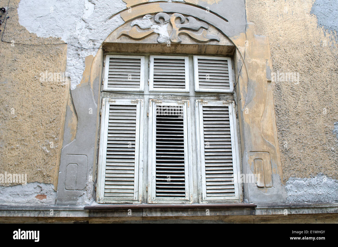 Old rotting wooden window on the crumbling wall in Bulgarian style ...