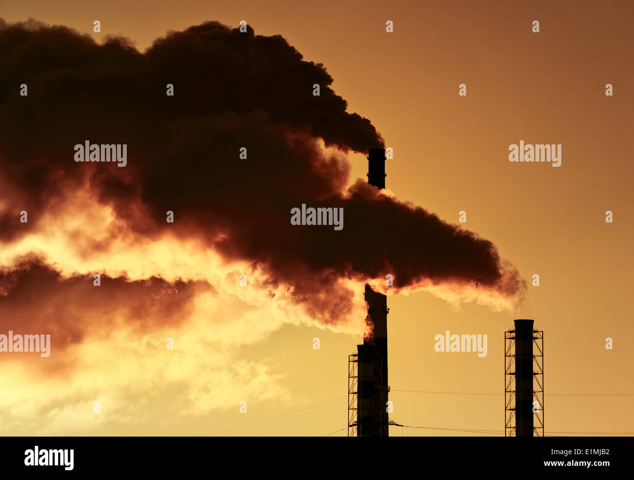 Smoke from pipes on sunset background Stock Photo - Alamy