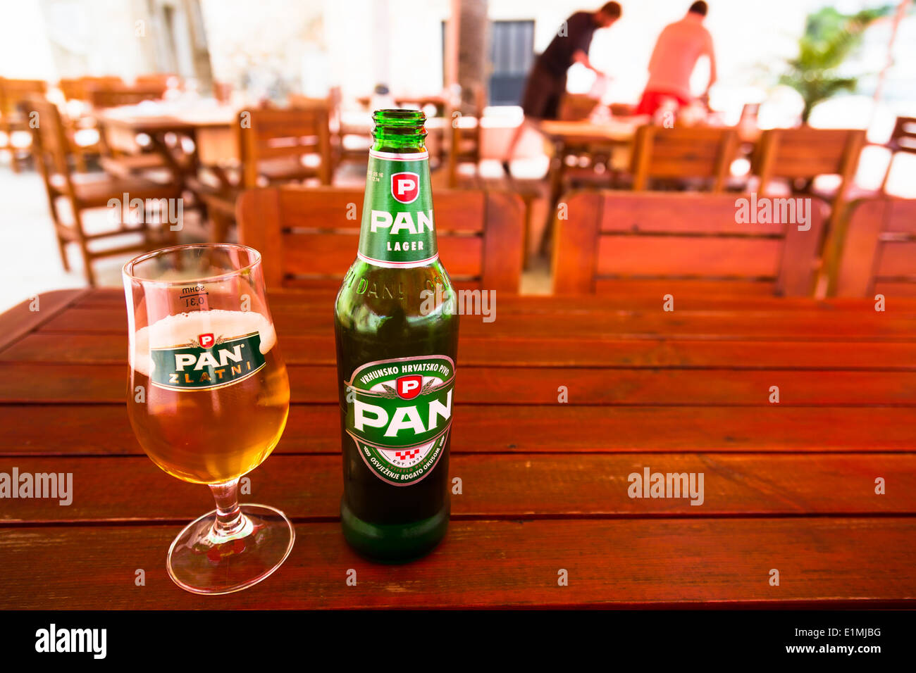half filled bottle and glass of pan lager beer which is brewed in ...