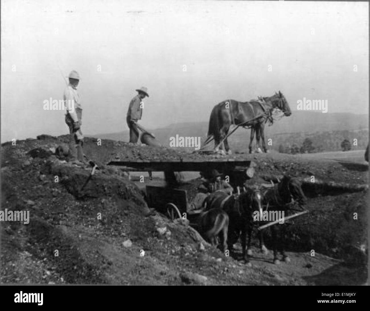A construction site with people and animals, featuring black and white ...