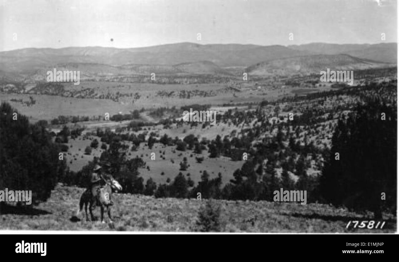 A black-and-white photograph depicting an Apache man on horseback in a ...