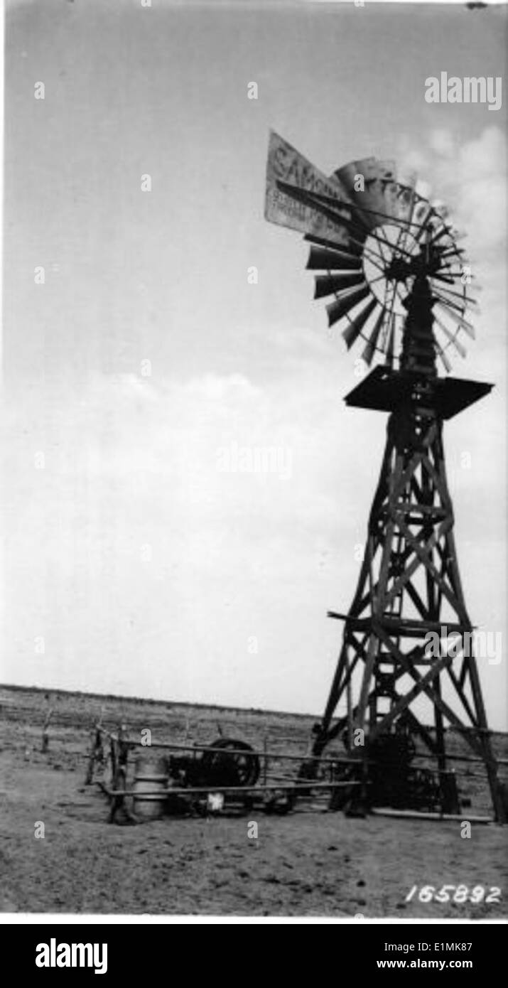 A black-and-white image of a windmill in an open range, symbolizing the ...
