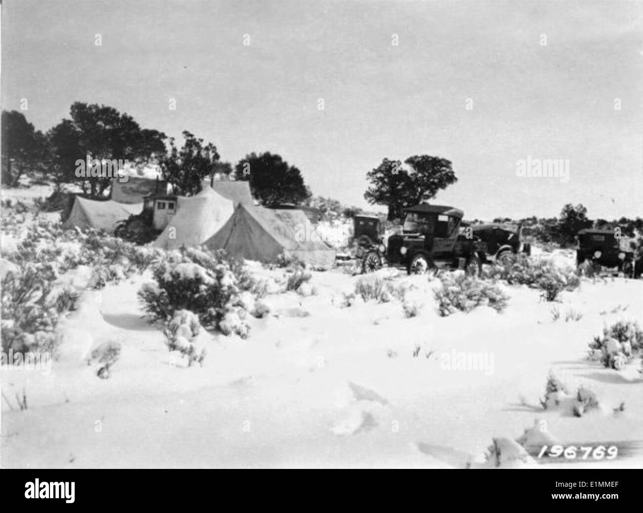 A black-and-white historic photograph showing indigenous people camping ...