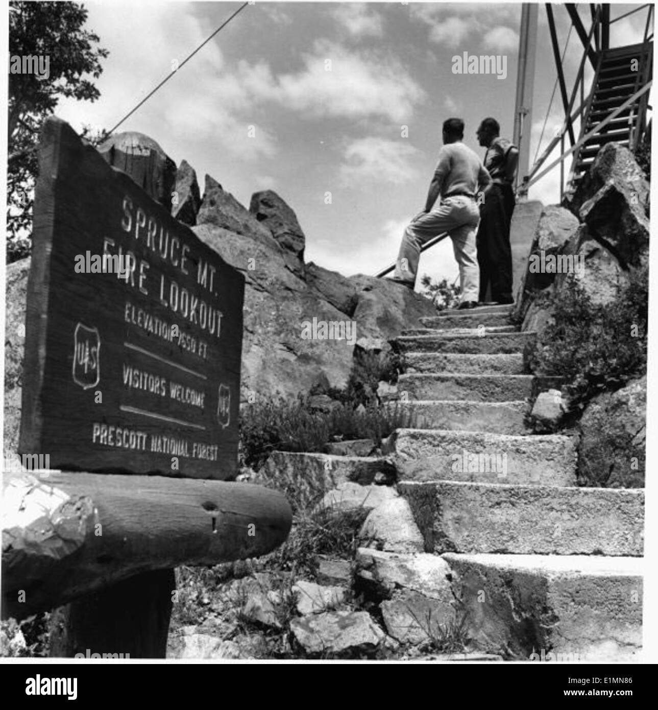 A historical black-and-white photograph of men at a lookout point in ...
