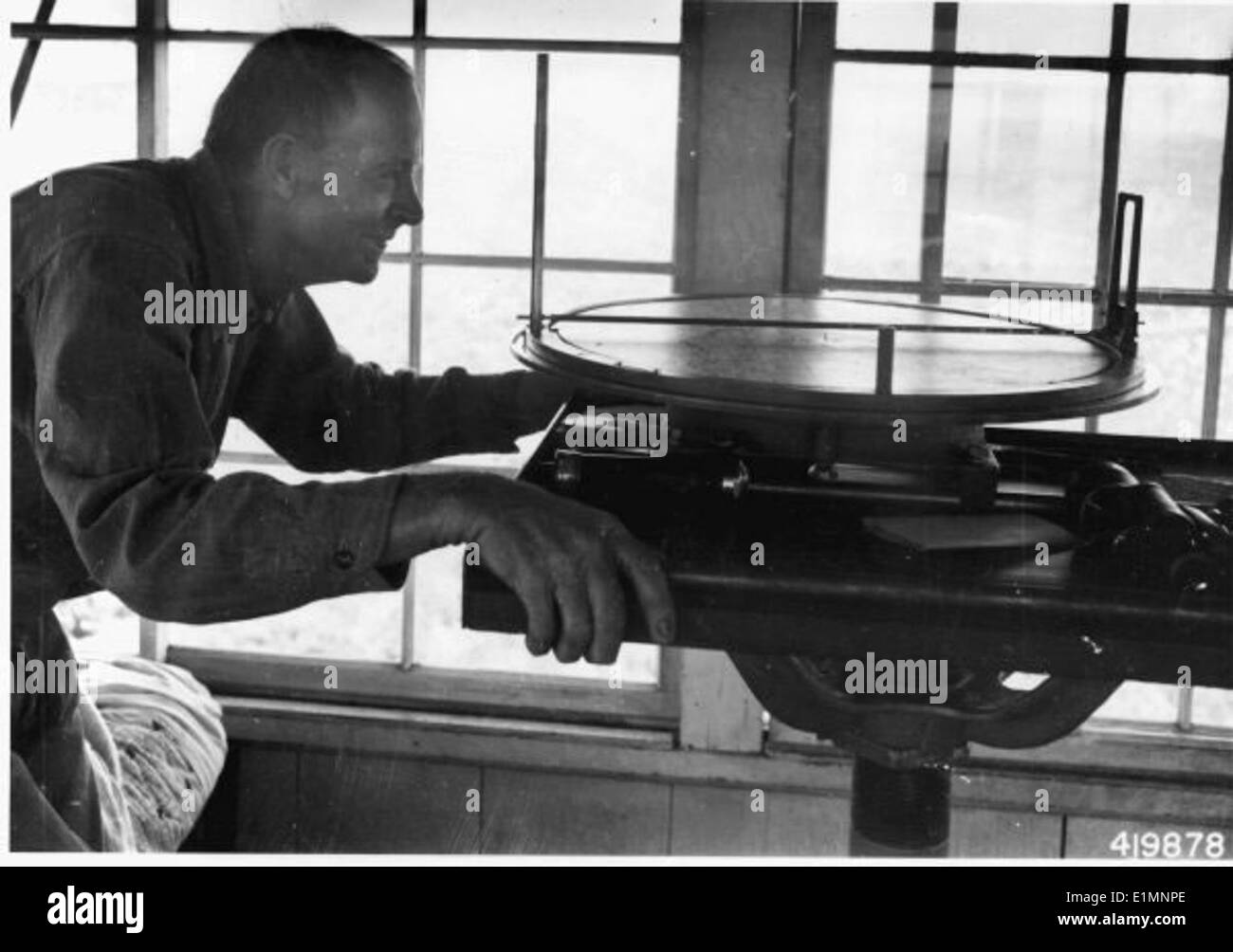 This black-and-white photograph depicts forest workers using a lookout ...