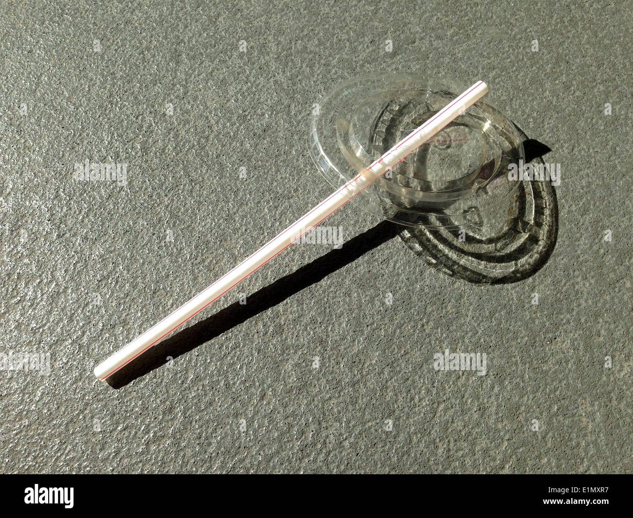 Discarded straw and plastic lid on pavement Stock Photo - Alamy
