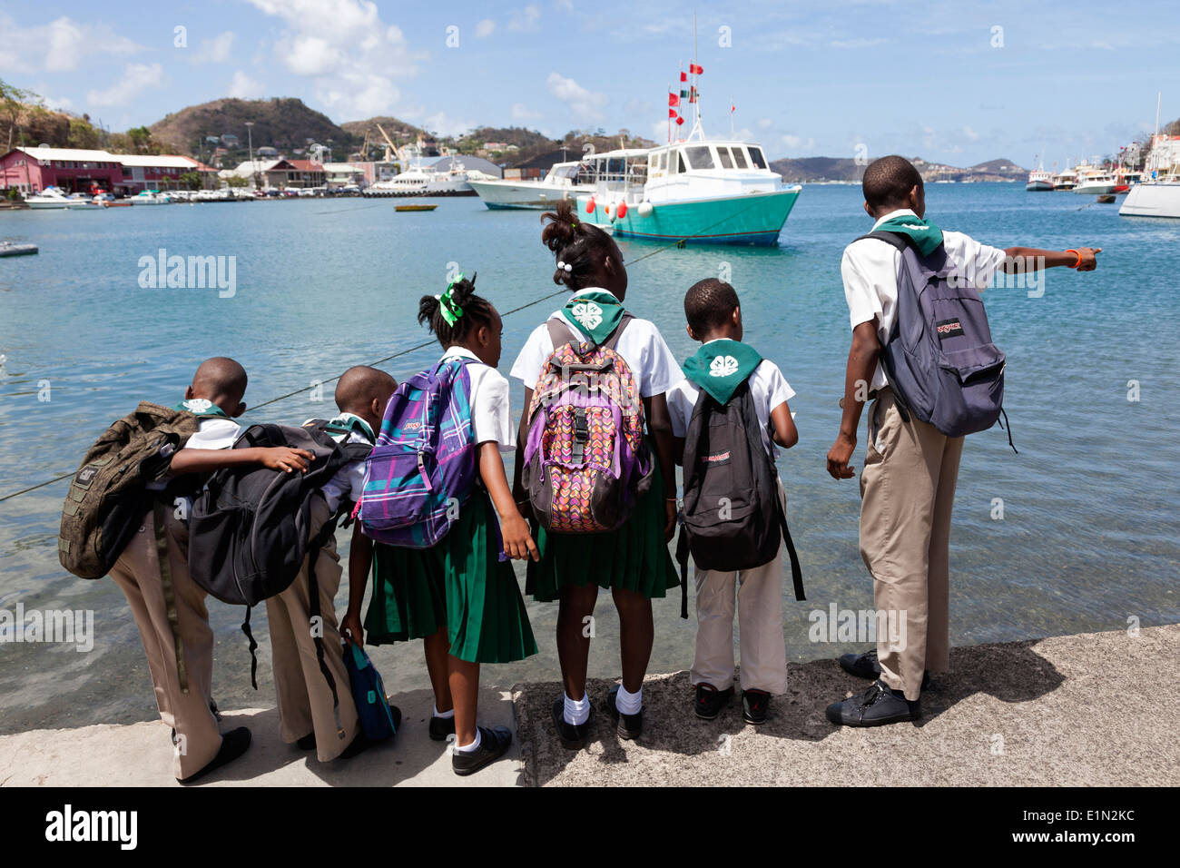 Six school children standing on the harbour walkway and looking out to ...