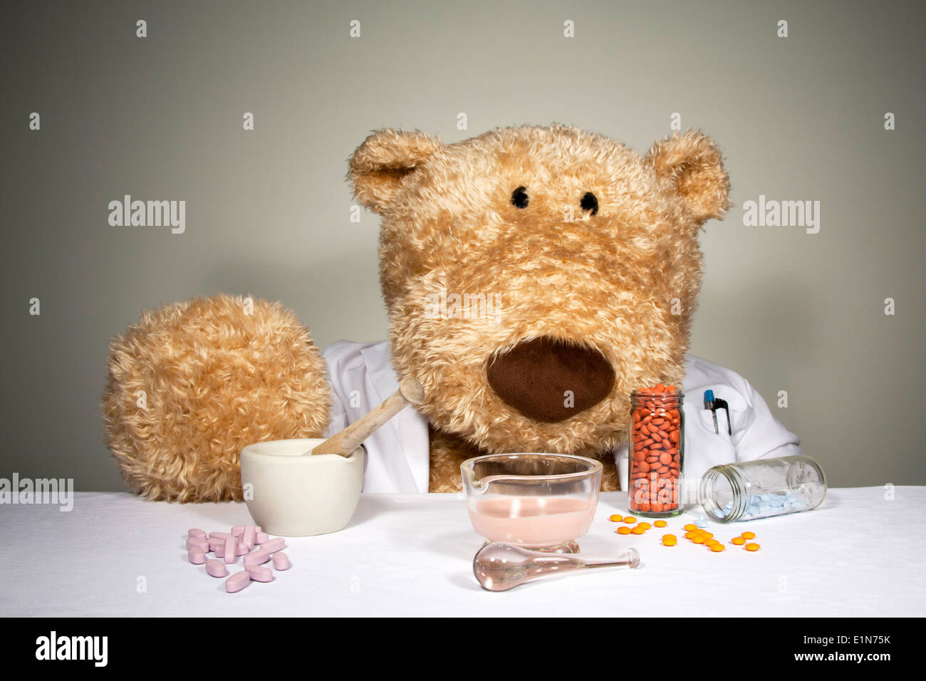 Oversized teddy bear dressed in pharmacist white lab coat surrounded by ...