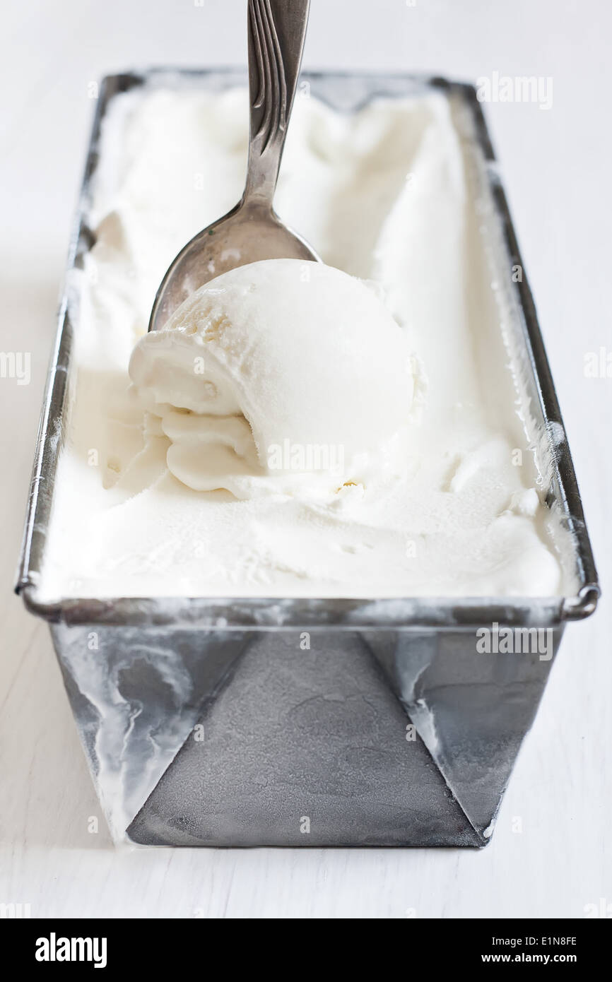 Homemade vanila ice cream in frozen metalic container. Selective focus ...