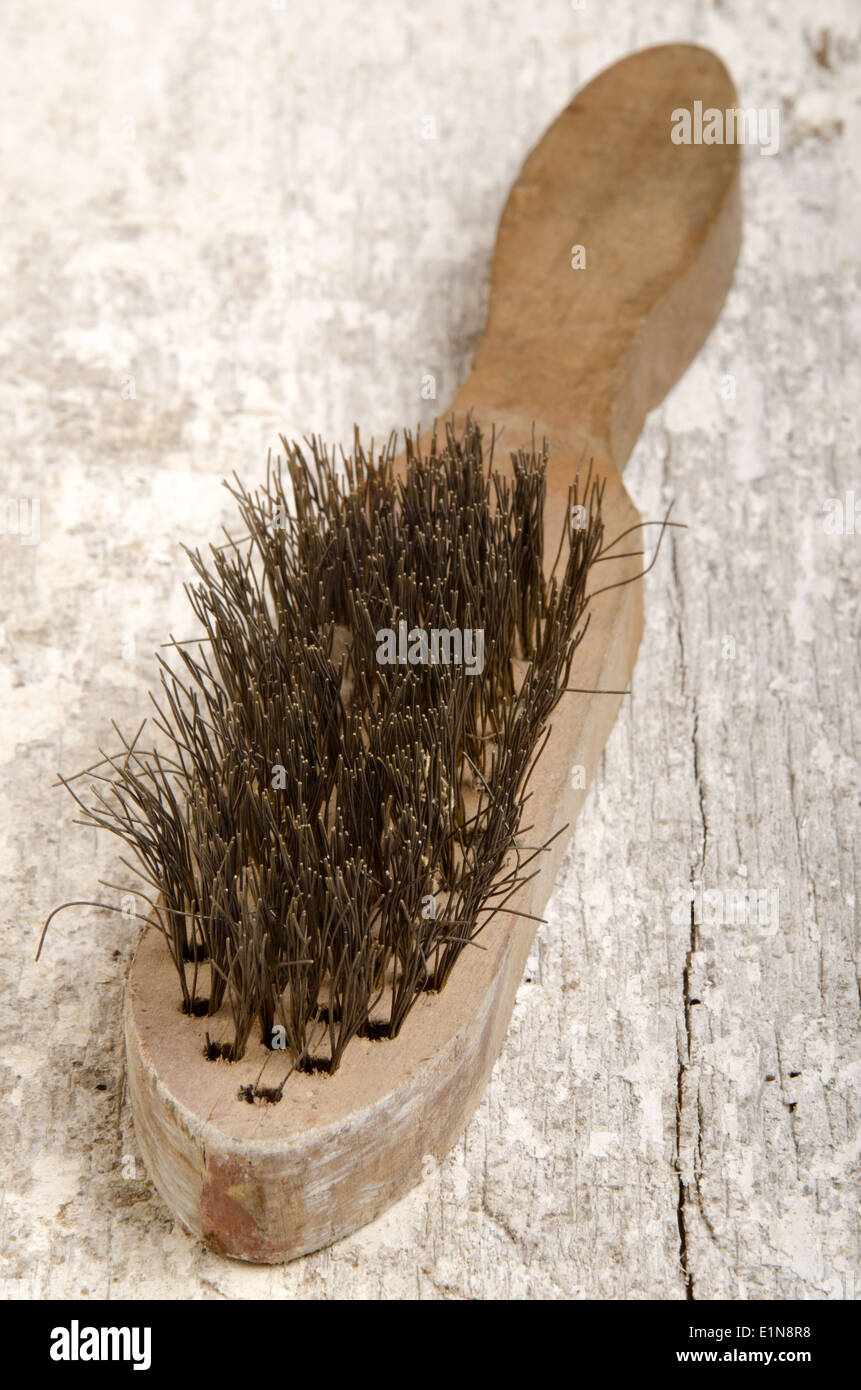 old and rusty wire brush on white wood Stock Photo - Alamy