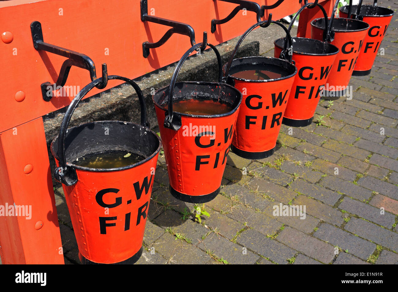 Row of red Victorian Fire buckets on the railway platform, Hampton ...