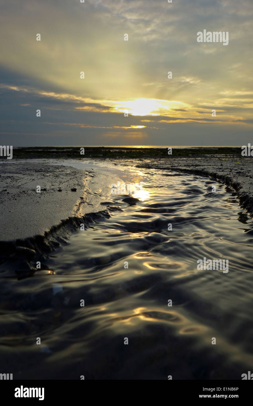 Stream across beach shore Stock Photo - Alamy