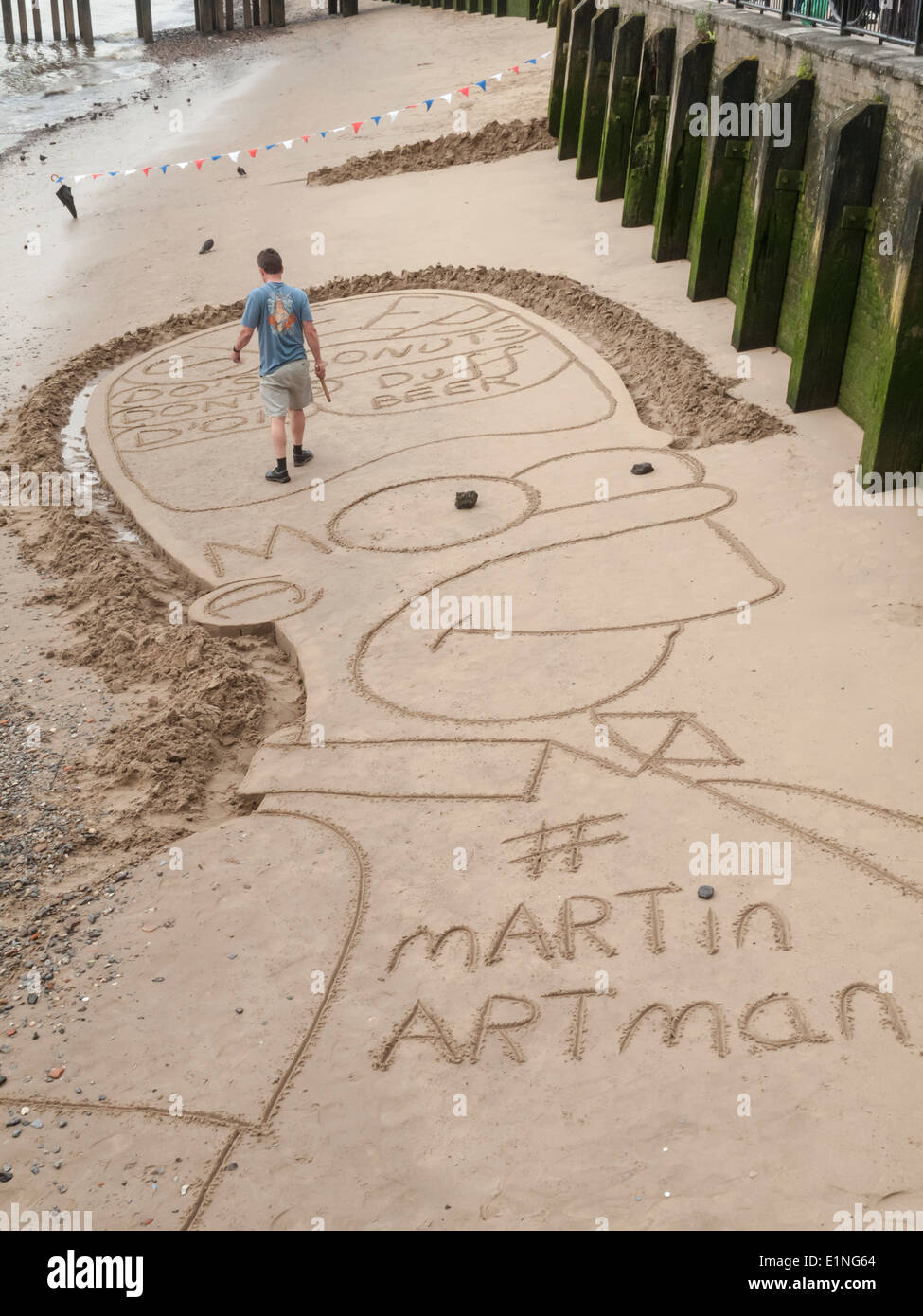 Homer Simpson head drawn in a sand bank on the shore of the River ...