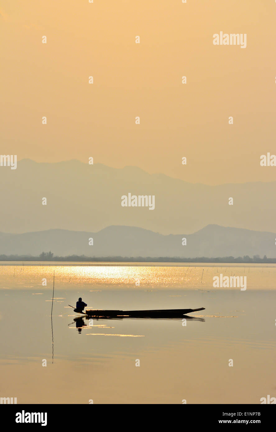 fisherman is fishing and glistening lake background in sepia color ...