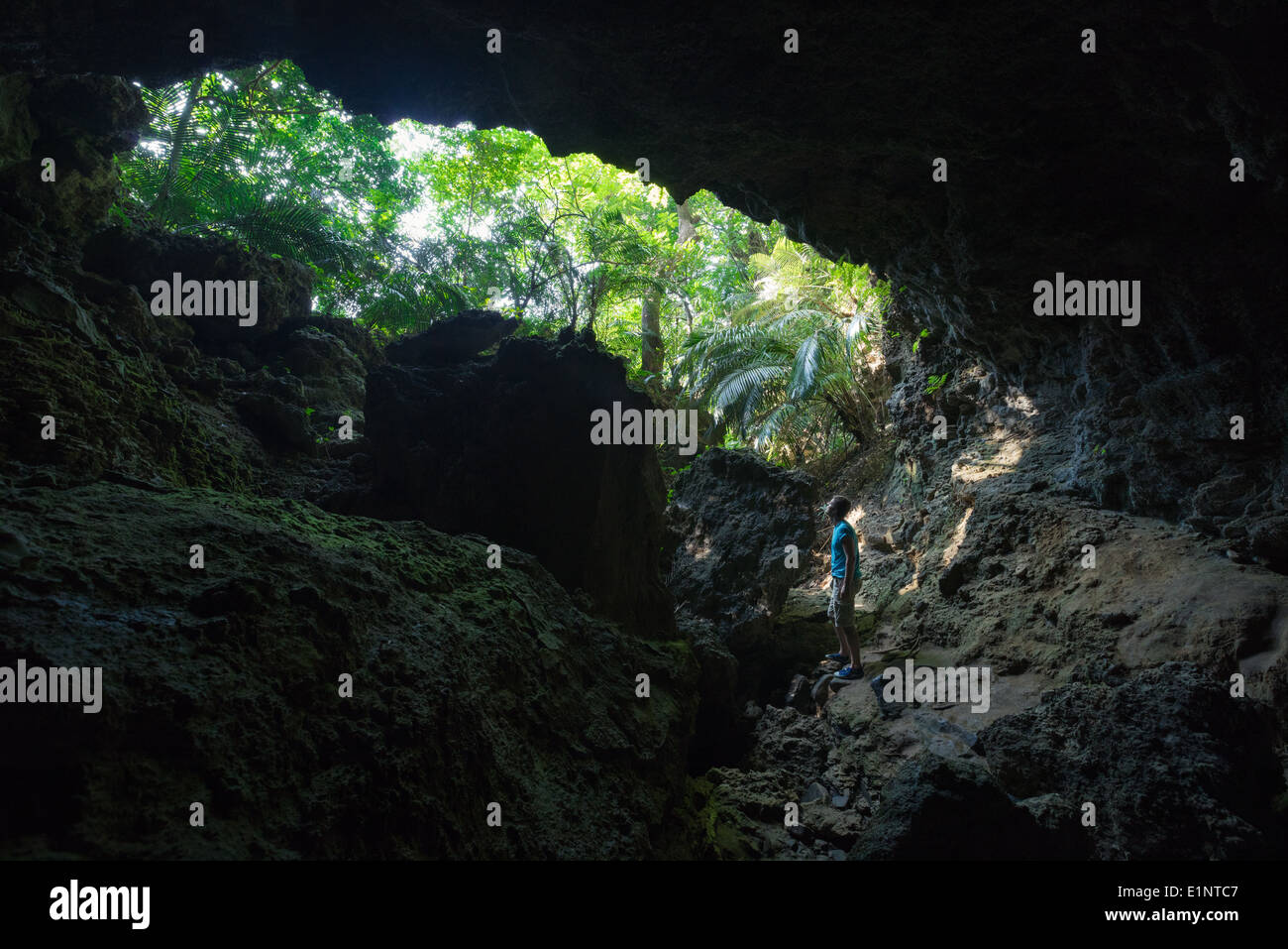 Man exploring huge limestone cave deep in the untouched rain forest of ...