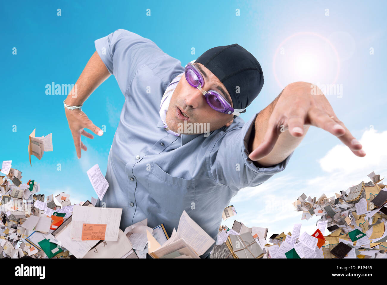 Businessman swimming in a sea of papers Stock Photo - Alamy