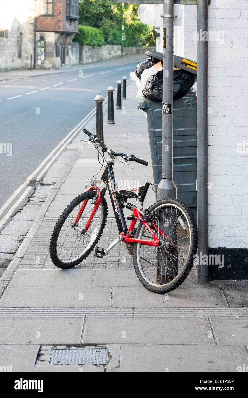 Bicycle chained to metal post obstructing pavement sidewalk with saddle ...
