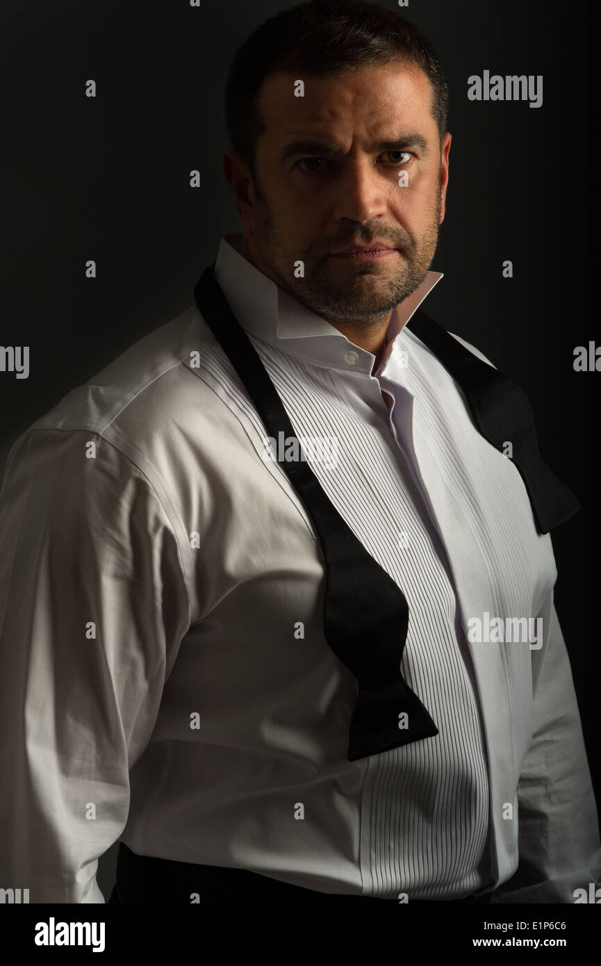Low key portrait of handsome male wearing shirt and bow tie looking ...