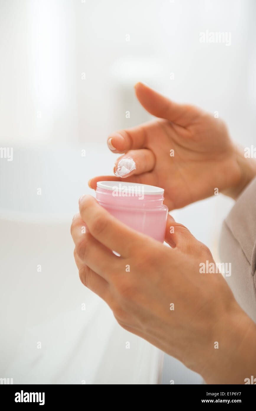 Closeup on young woman applying cream Stock Photo - Alamy