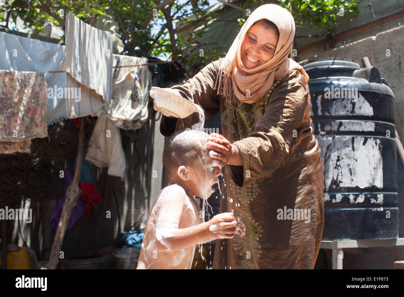 Gaza City, Gaza Strip. 8th June, 2014. A Palestinian mother bathing her ...