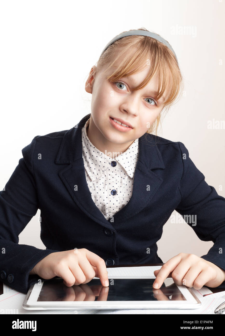 Little blond smiling schoolgirl with tablet device on the desk Stock ...