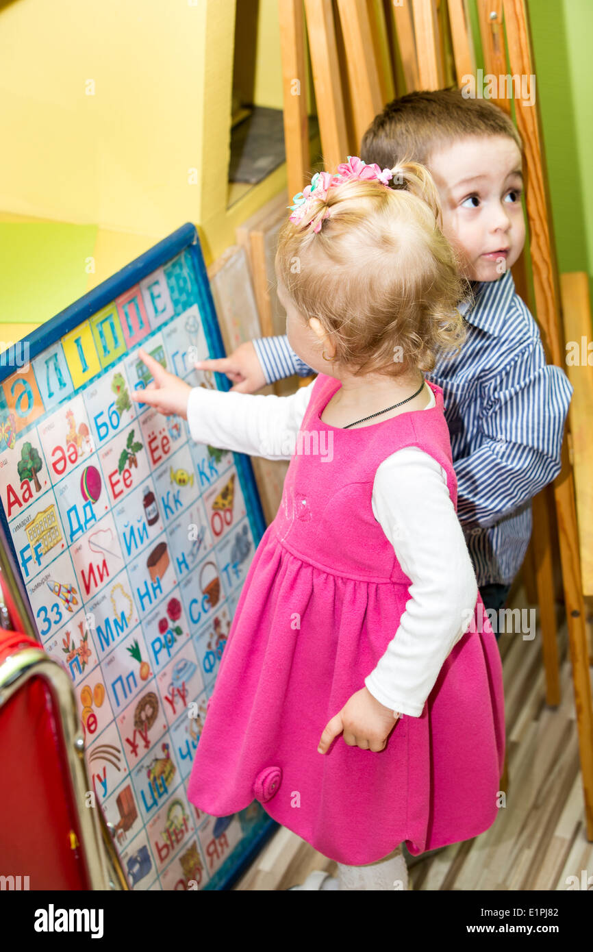 Two kids in Montessori preschool Class. Little girl and boy playing in ...