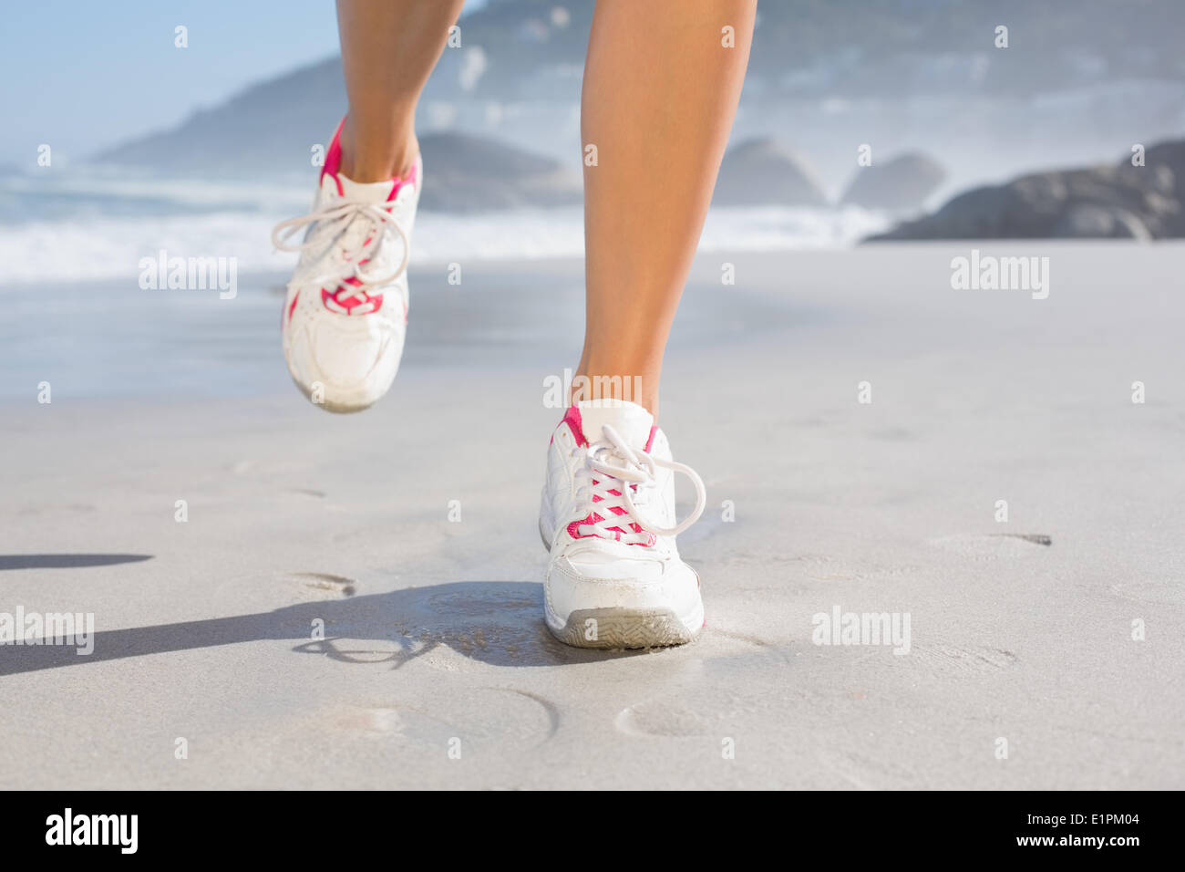 Fit woman walking on the beach Stock Photo - Alamy