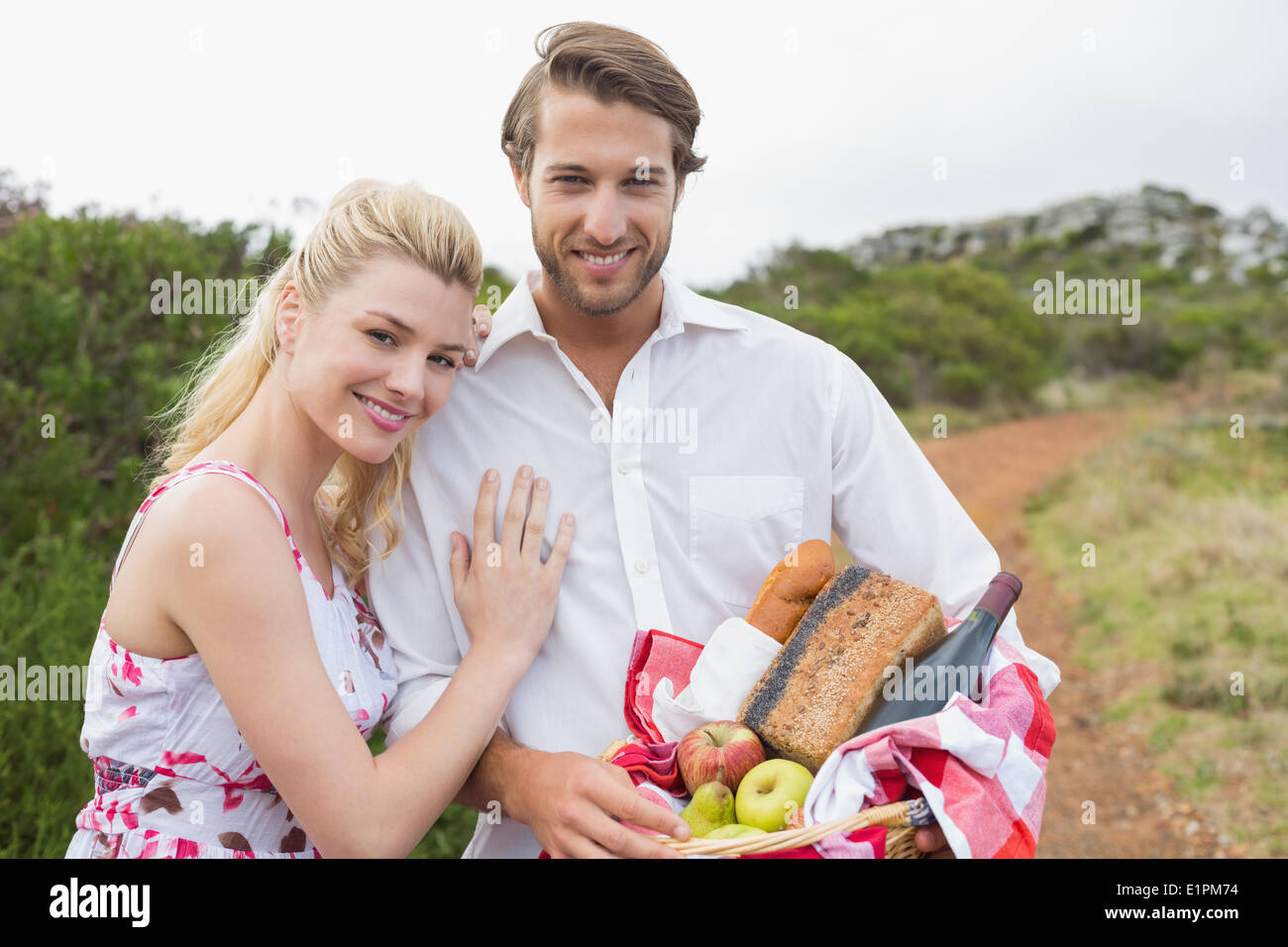 Cute couple going for a picnic smiling at camera Stock Photo - Alamy