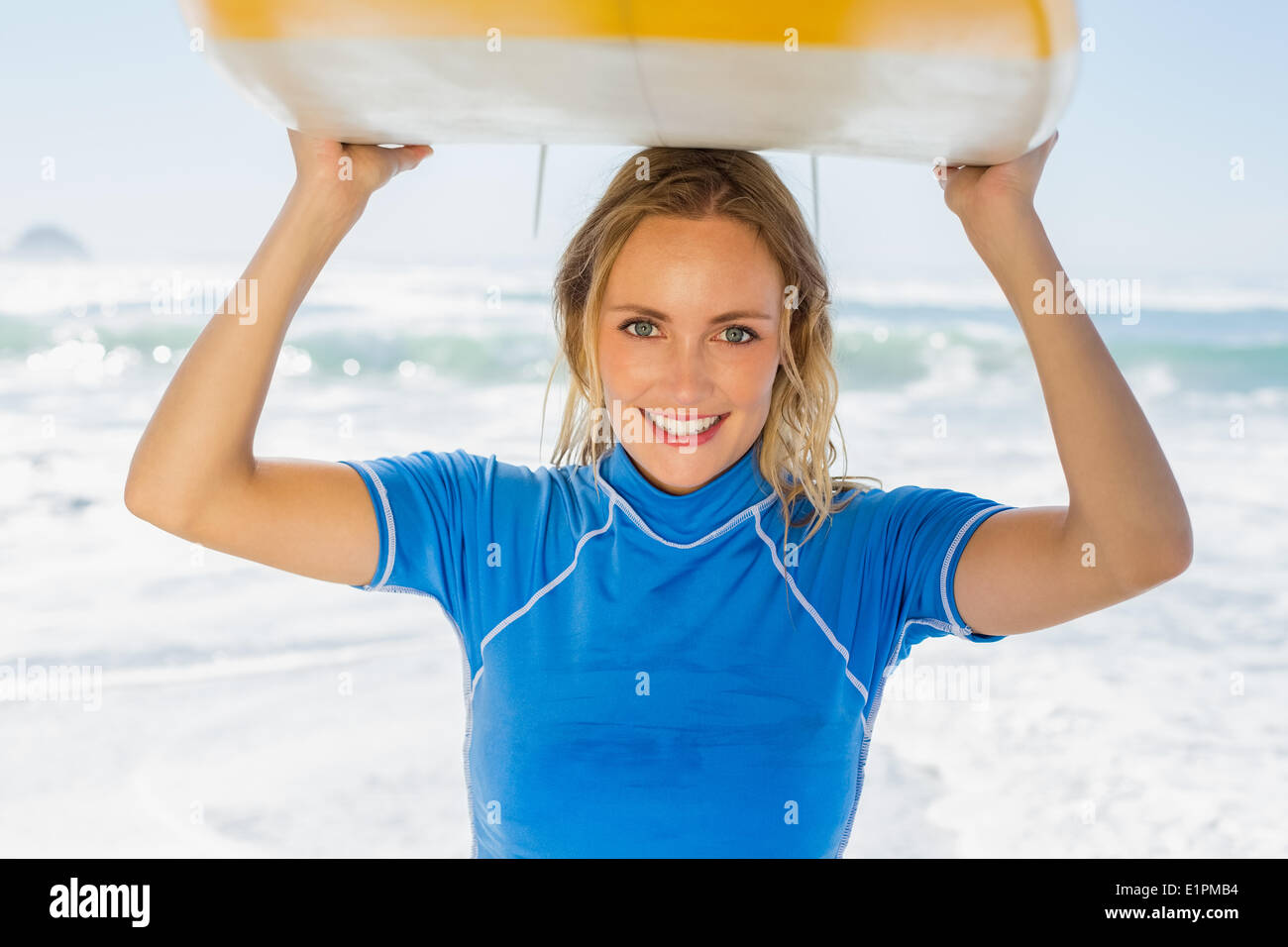 Blonde happy surfer holding her board on the beach Stock Photo - Alamy