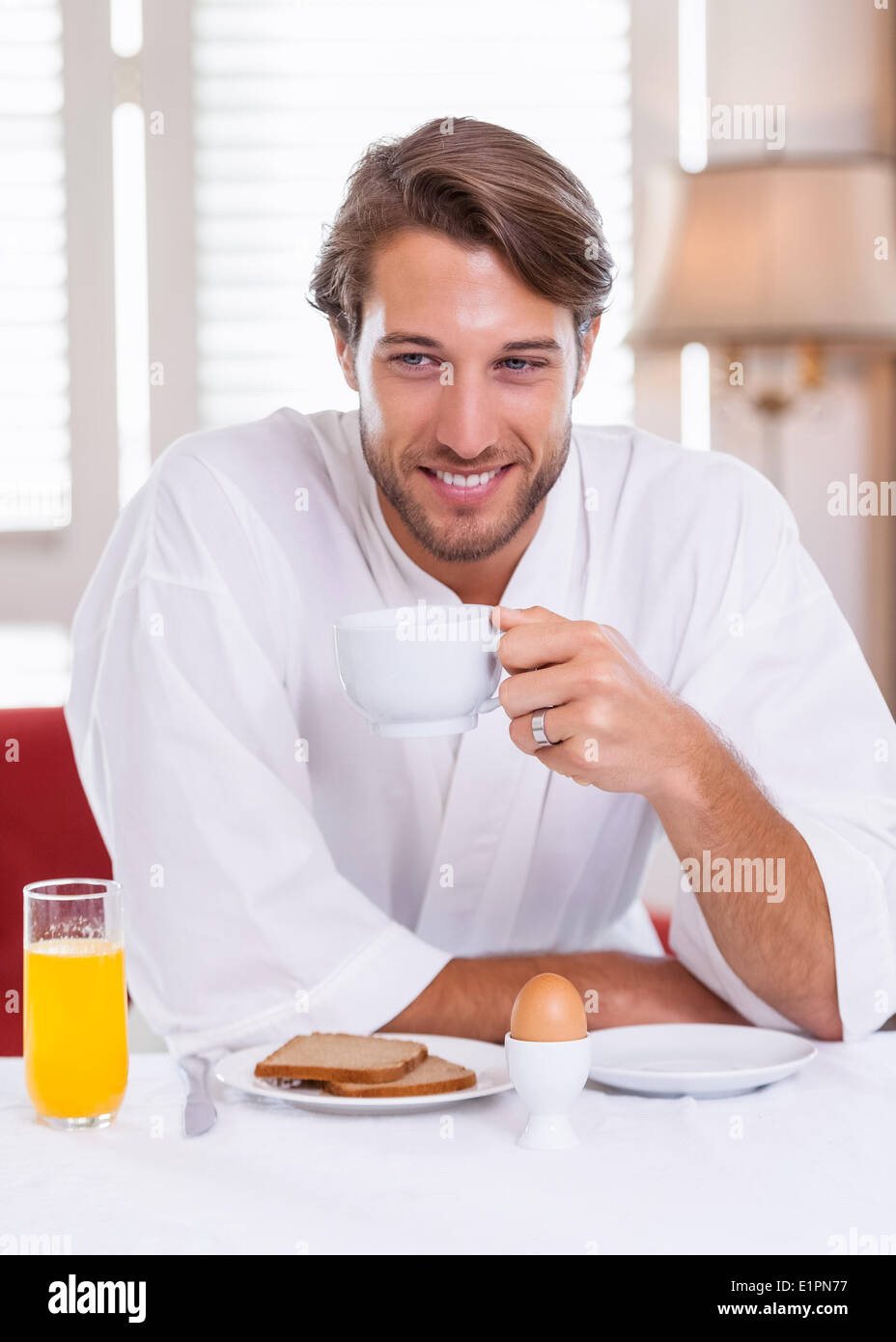 Handsome man having breakfast in his bathrobe Stock Photo - Alamy