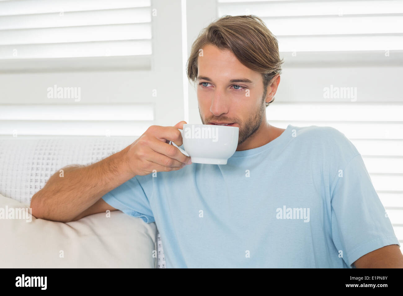 Handsome man sitting couch hi-res stock photography and images - Alamy