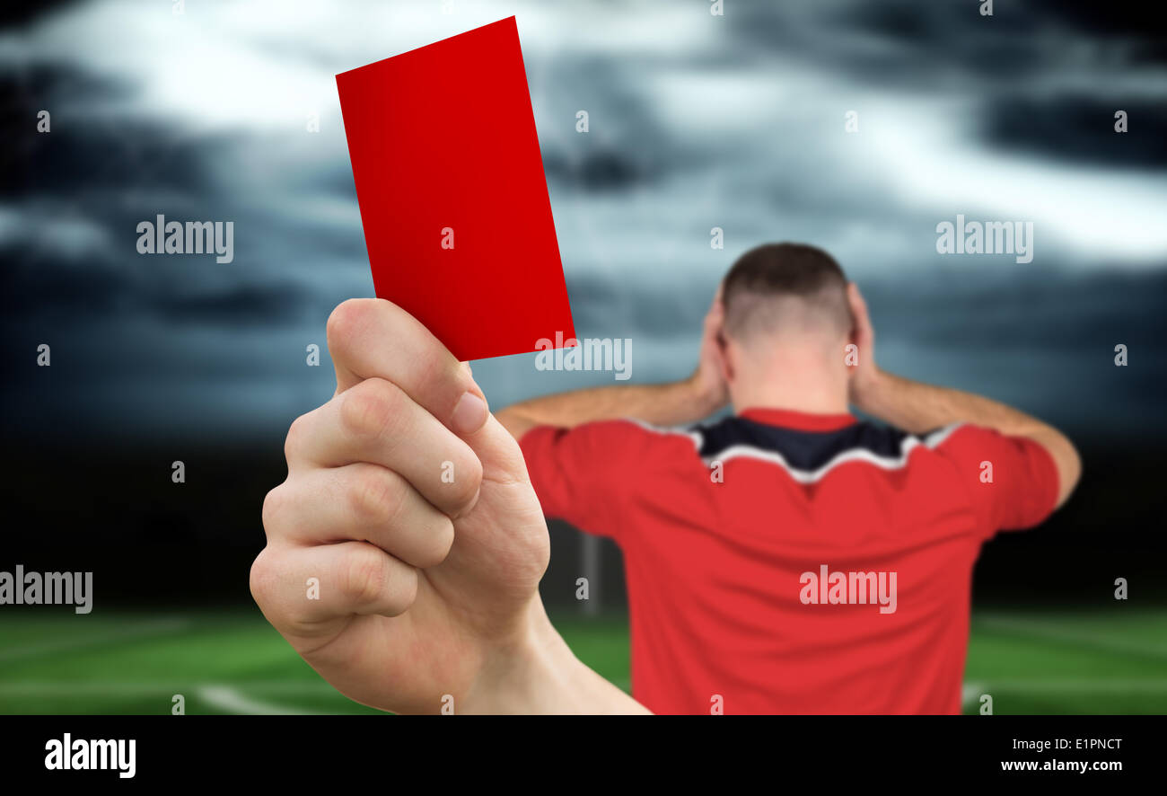 Composite image of hand holding up red card to player Stock Photo - Alamy