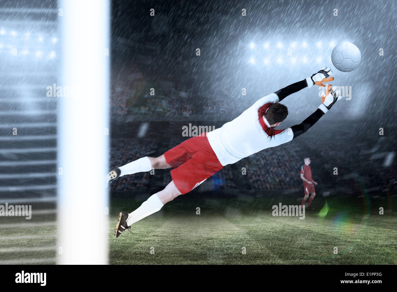 Composite image of goalkeeper in white jumping up Stock Photo - Alamy