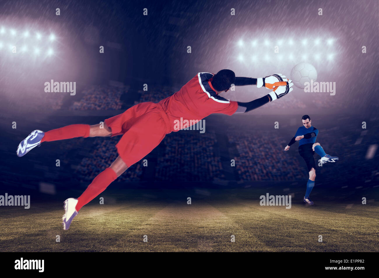 Composite image of goalkeeper in red making a save Stock Photo - Alamy