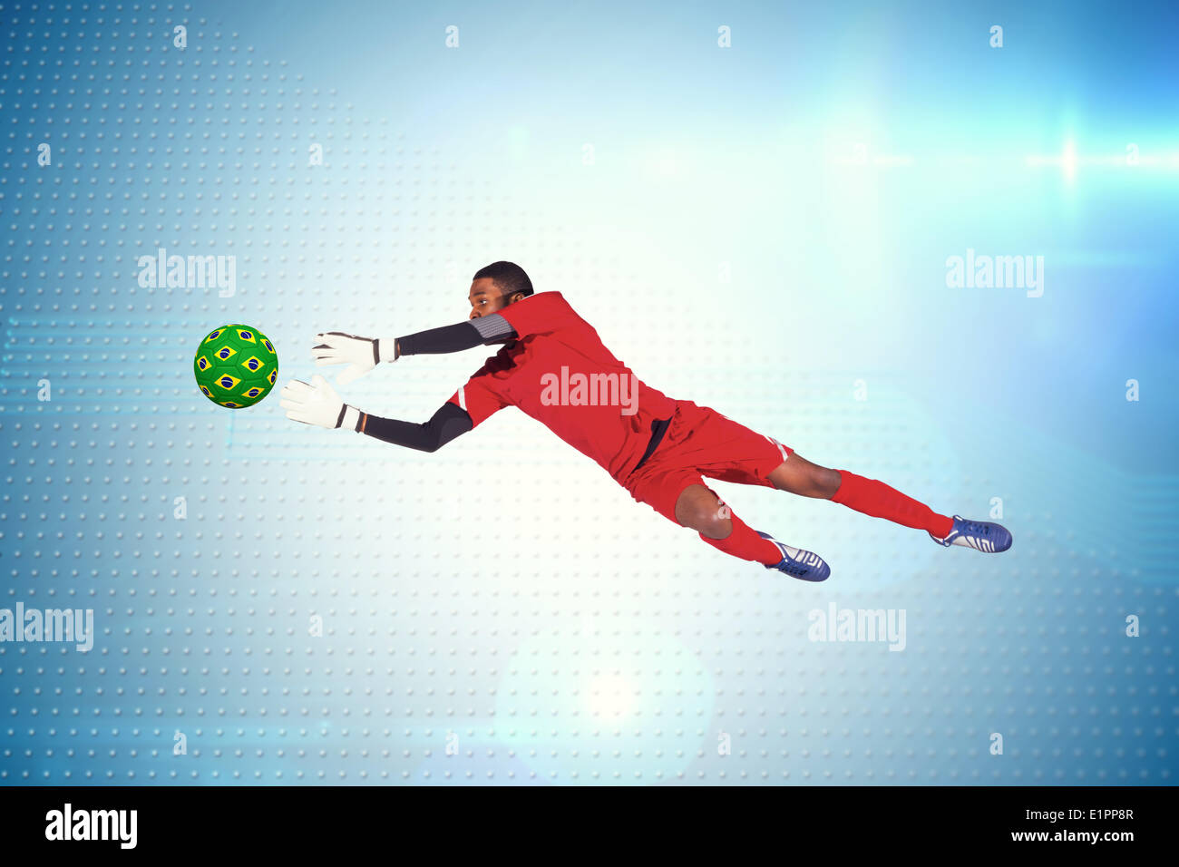 Composite image of goalkeeper in red making a save Stock Photo - Alamy