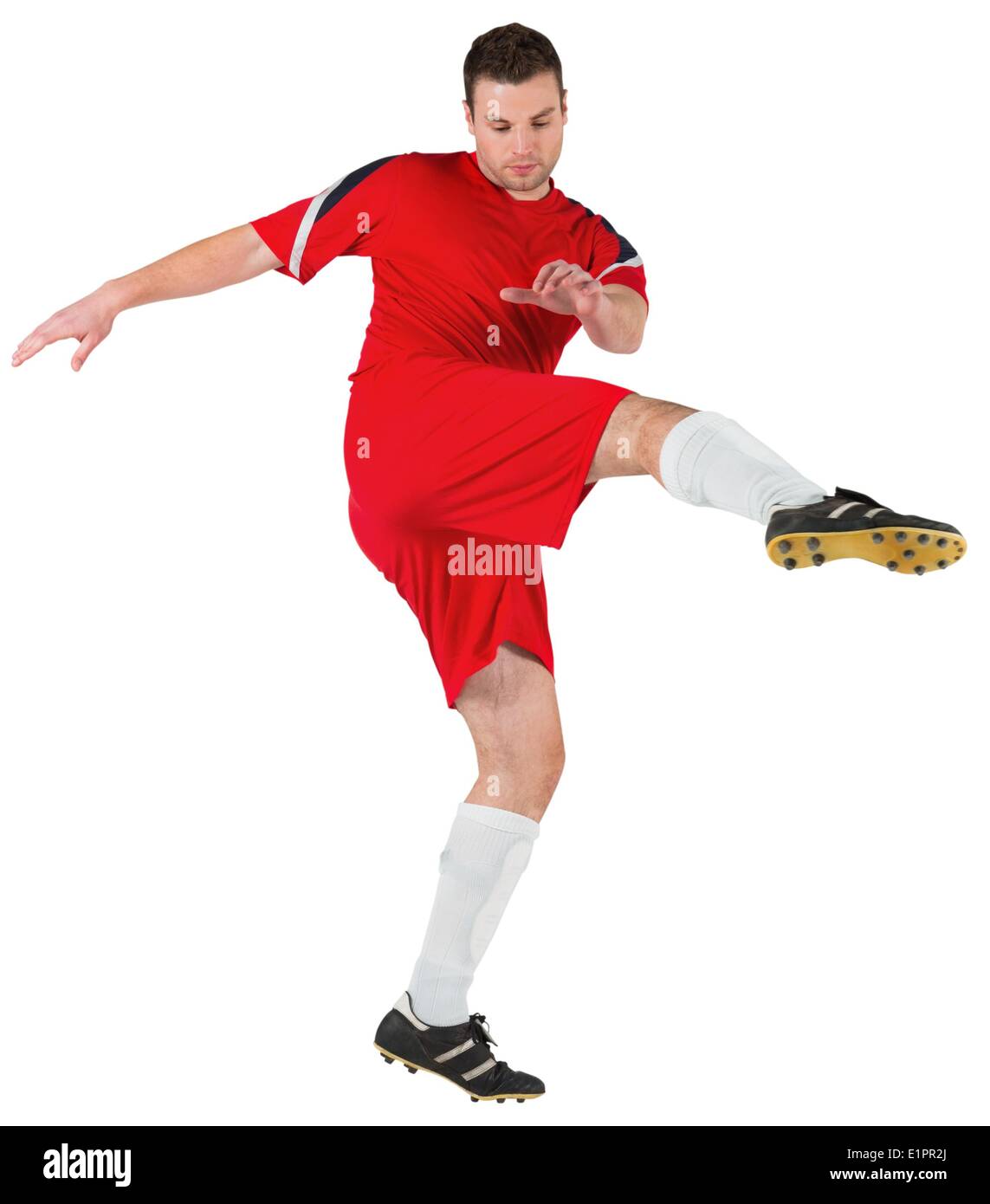 Football player in red kicking against black background with spark ...