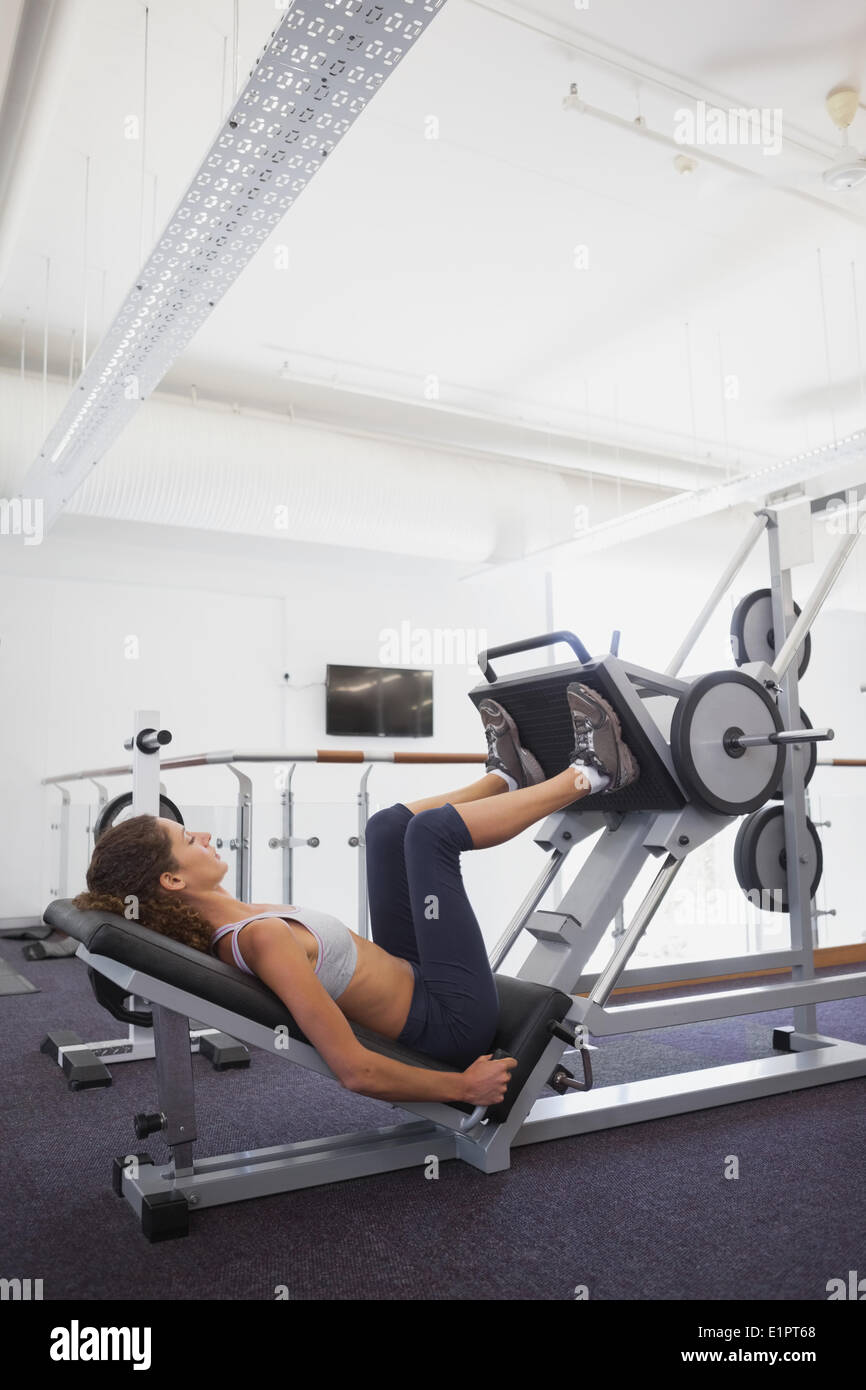 Fit woman using weights machine for legs Stock Photo - Alamy