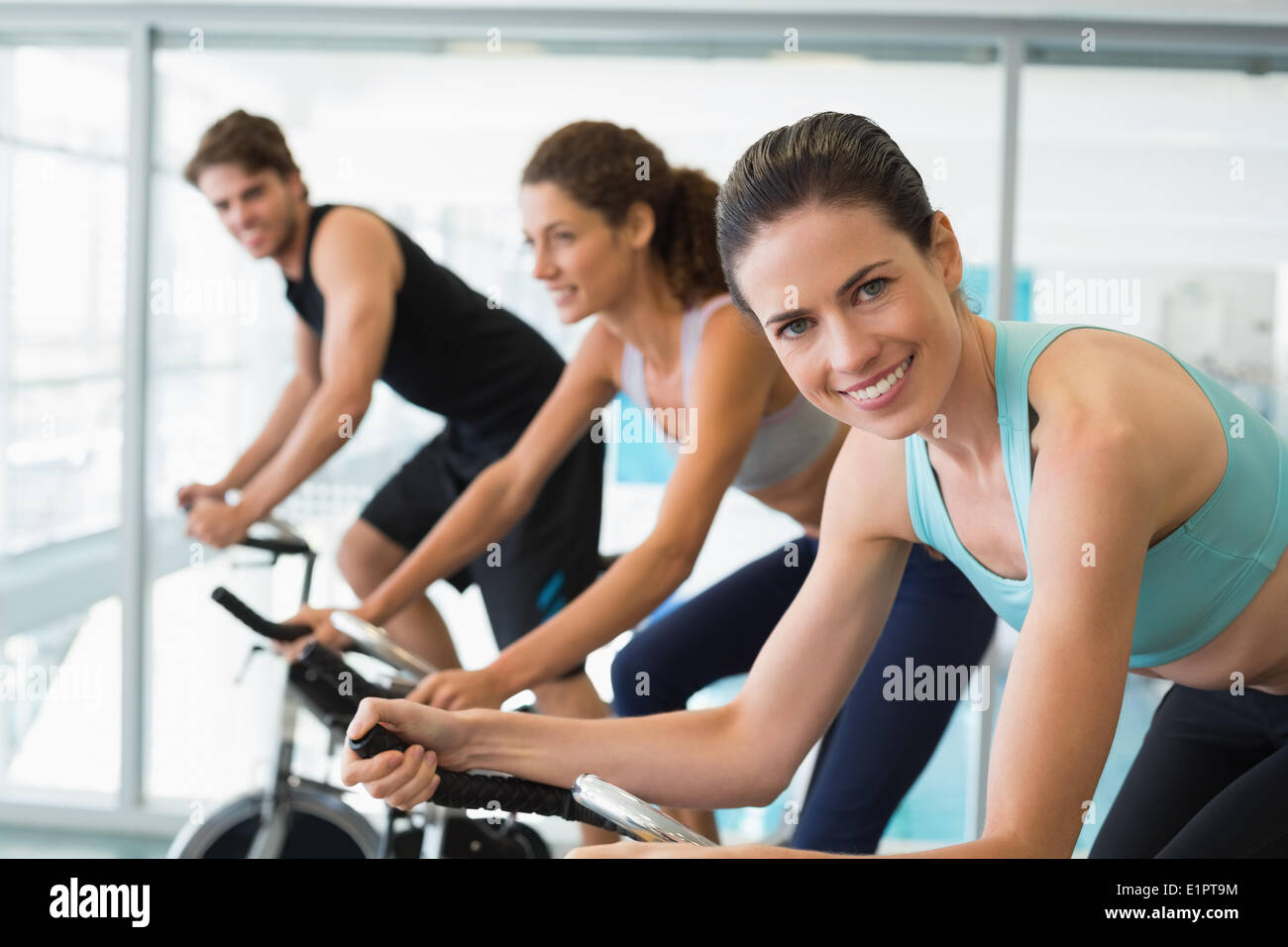 Fit people in a spin class with brunette smiling at camera Stock Photo ...