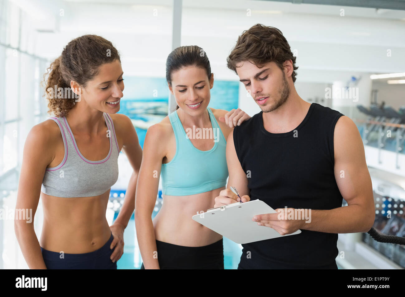 Fit women with trainer taking notes and smiling at camera Stock Photo ...