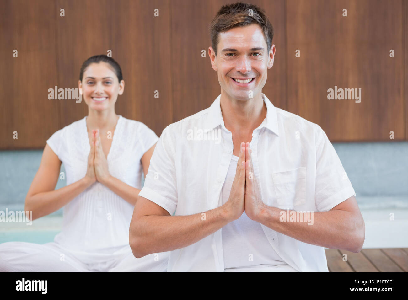 Peaceful couple in white sitting in lotus pose together Stock Photo - Alamy
