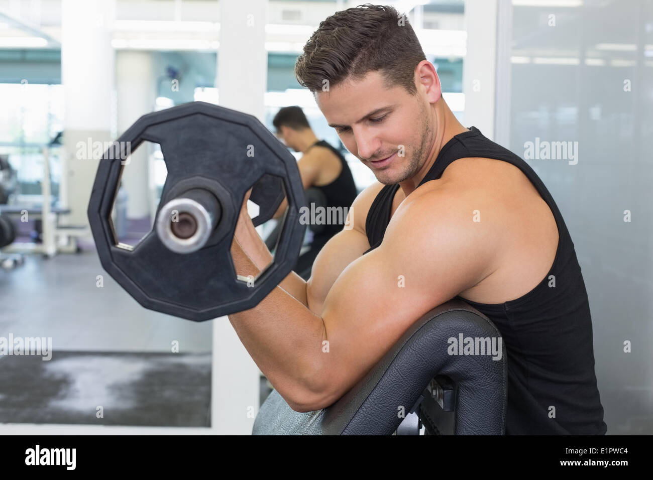 Focused bodybuilder lifting heavy black dumbbell Stock Photo - Alamy