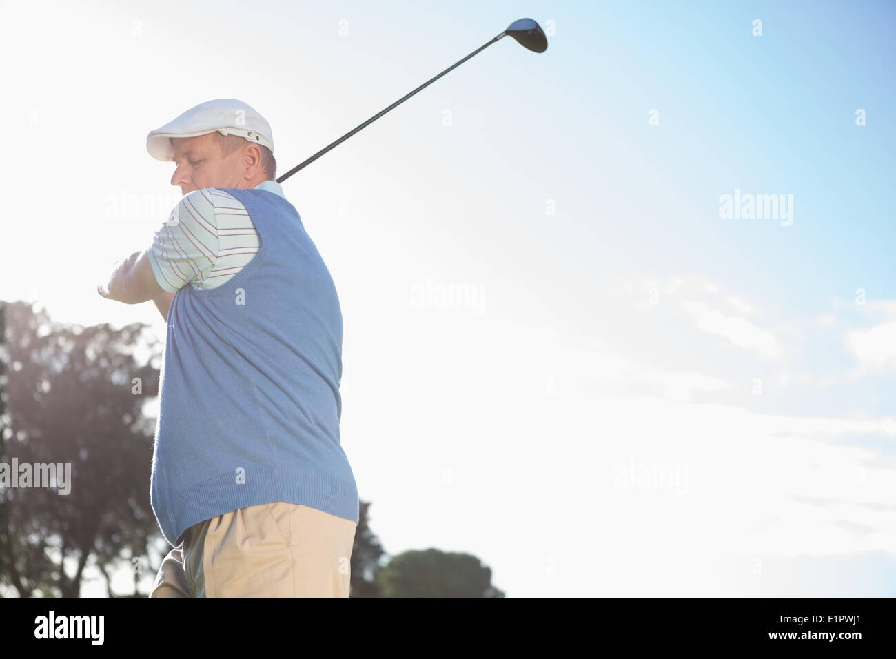 Golfer standing and swinging his club Stock Photo - Alamy