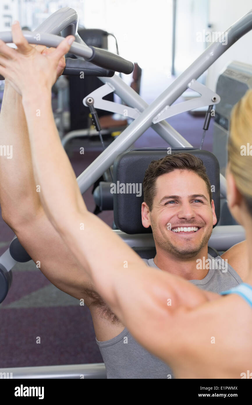 Personal trainer coaching bodybuilder using weight machine Stock Photo ...